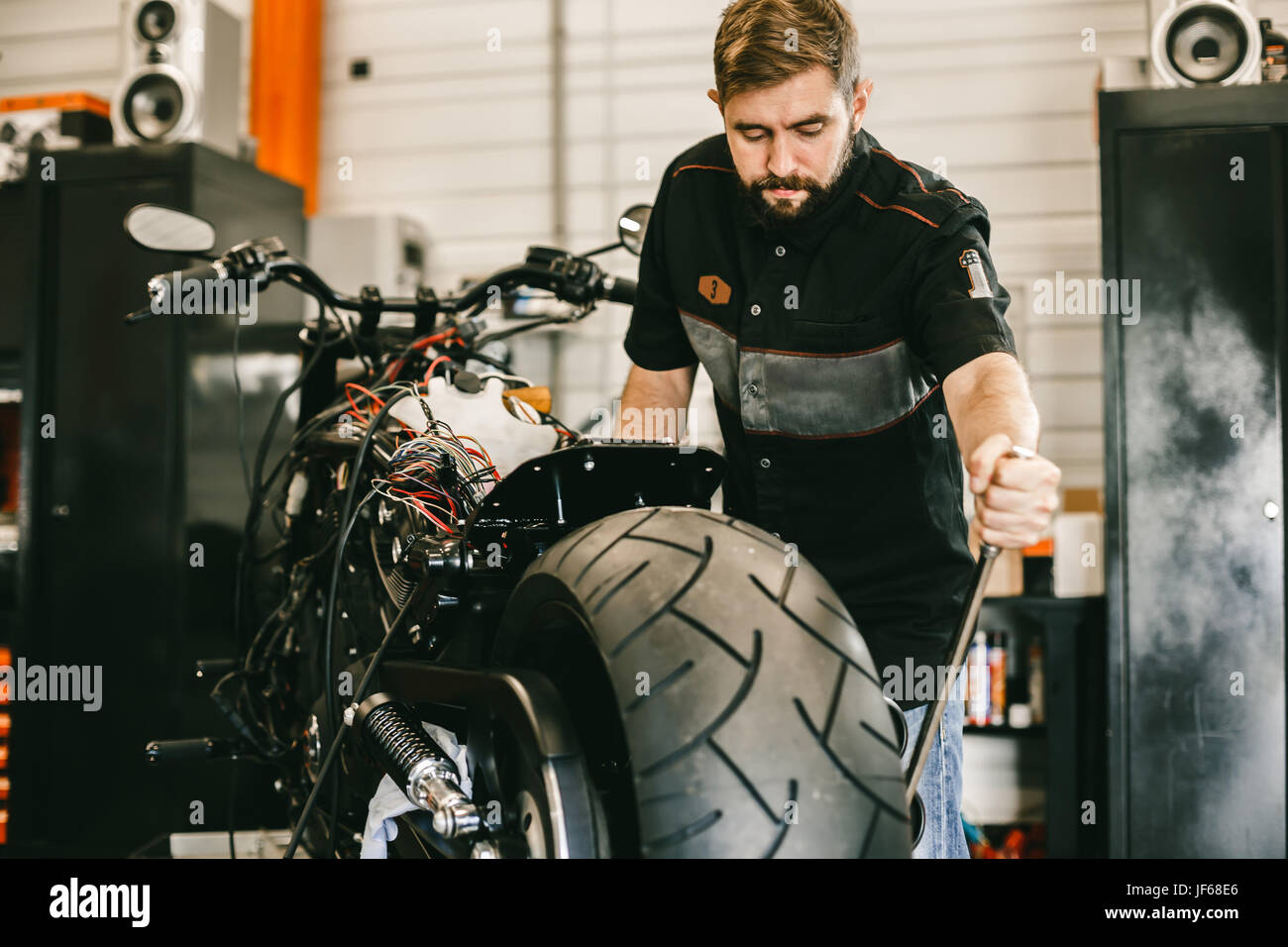 Mechanician changing motorcycle wheel in bike repair shop. Professional ...