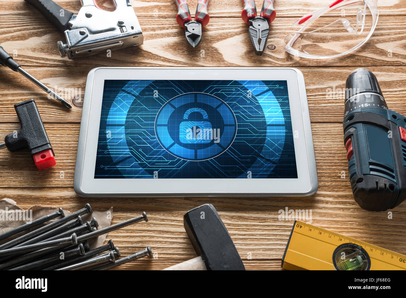 Tablet pc with security concept on screen and industrial tools around ...