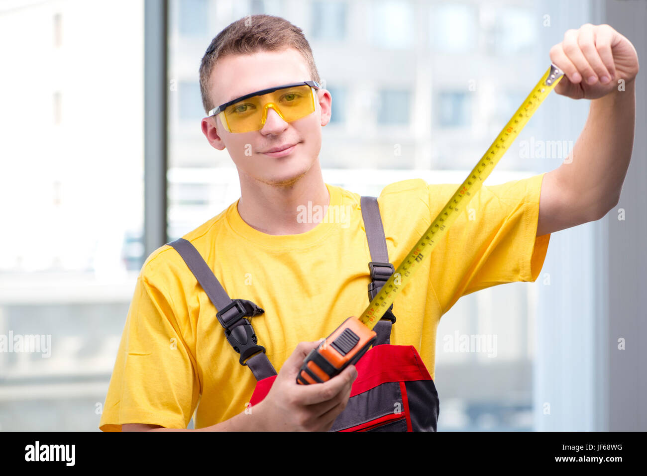 Young construction worker in yellow coveralls Stock Photo - Alamy