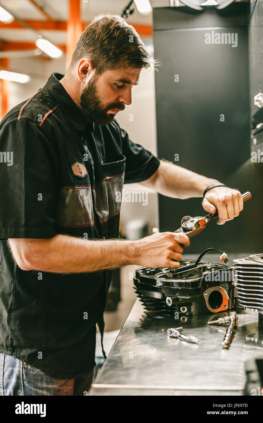 Motorcycle mechanic engine repair at service station. Motorcycle engine ...