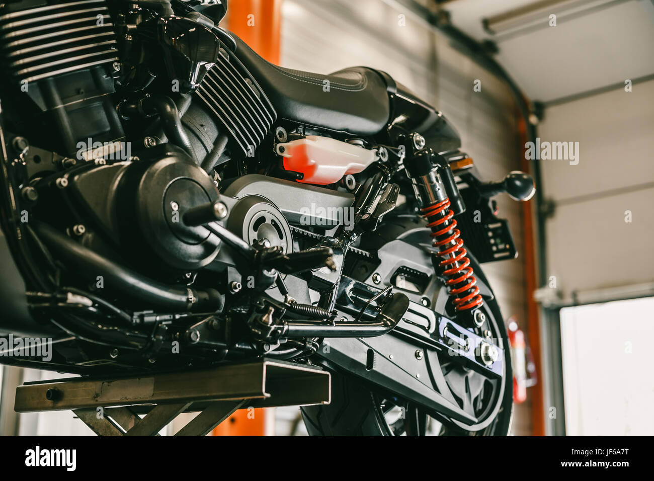 Close up side view of the motorcycle on the lift at the service station ...