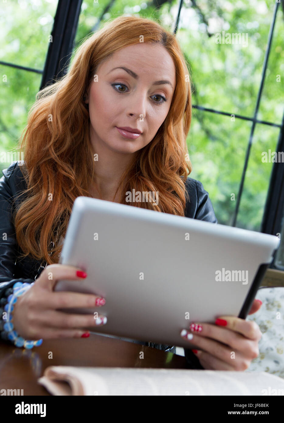 Pretty girl posing with a tablet in cafe Stock Photo - Alamy