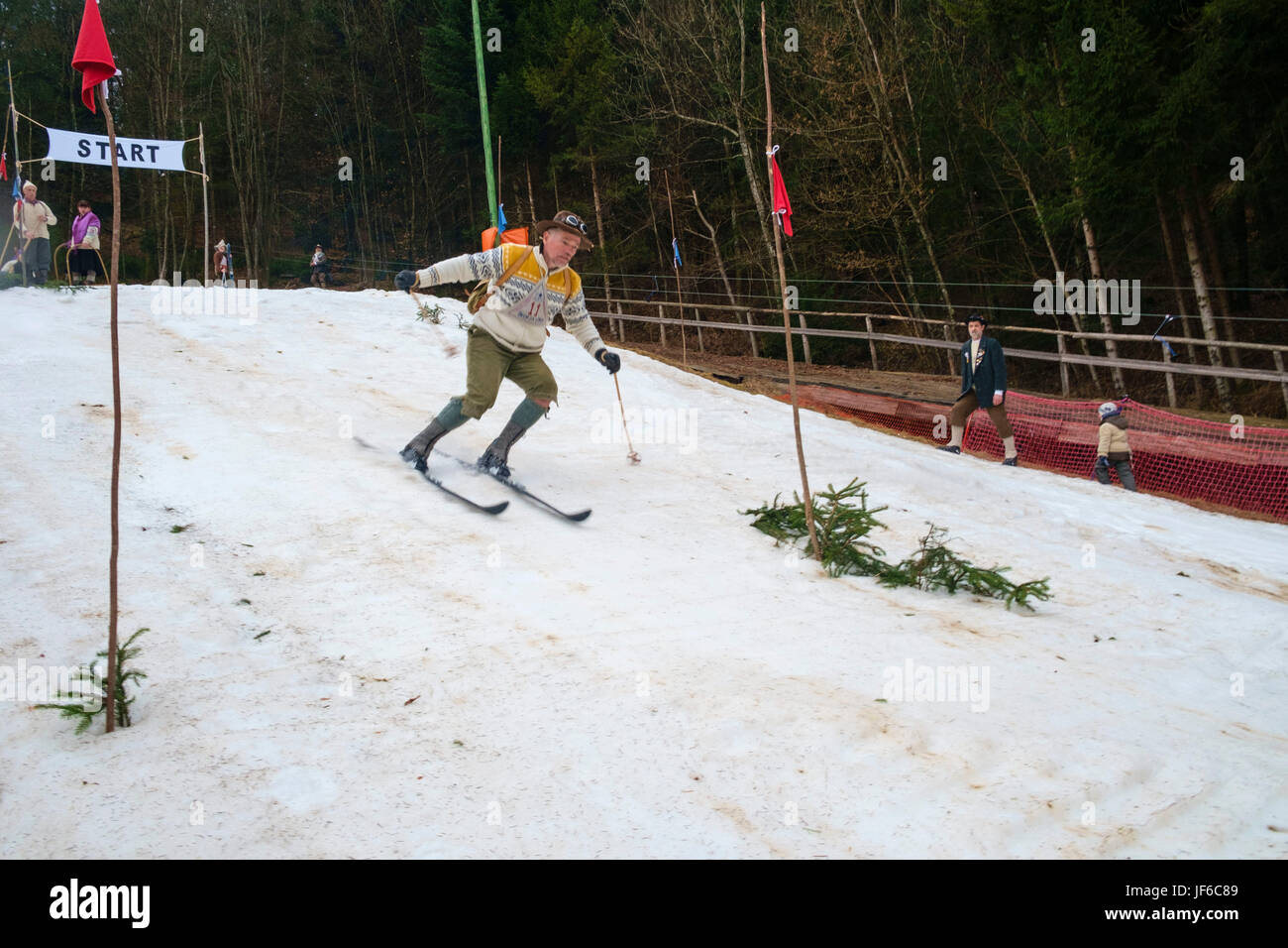Skiers in traditional retro style costumes, with old wooden ski gear at ...