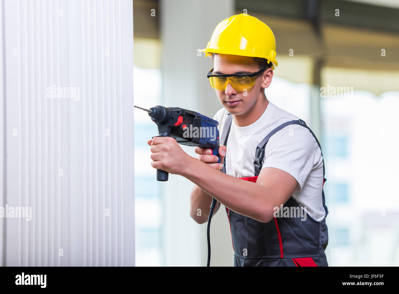 Man drilling the wall with drill perforator Stock Photo - Alamy