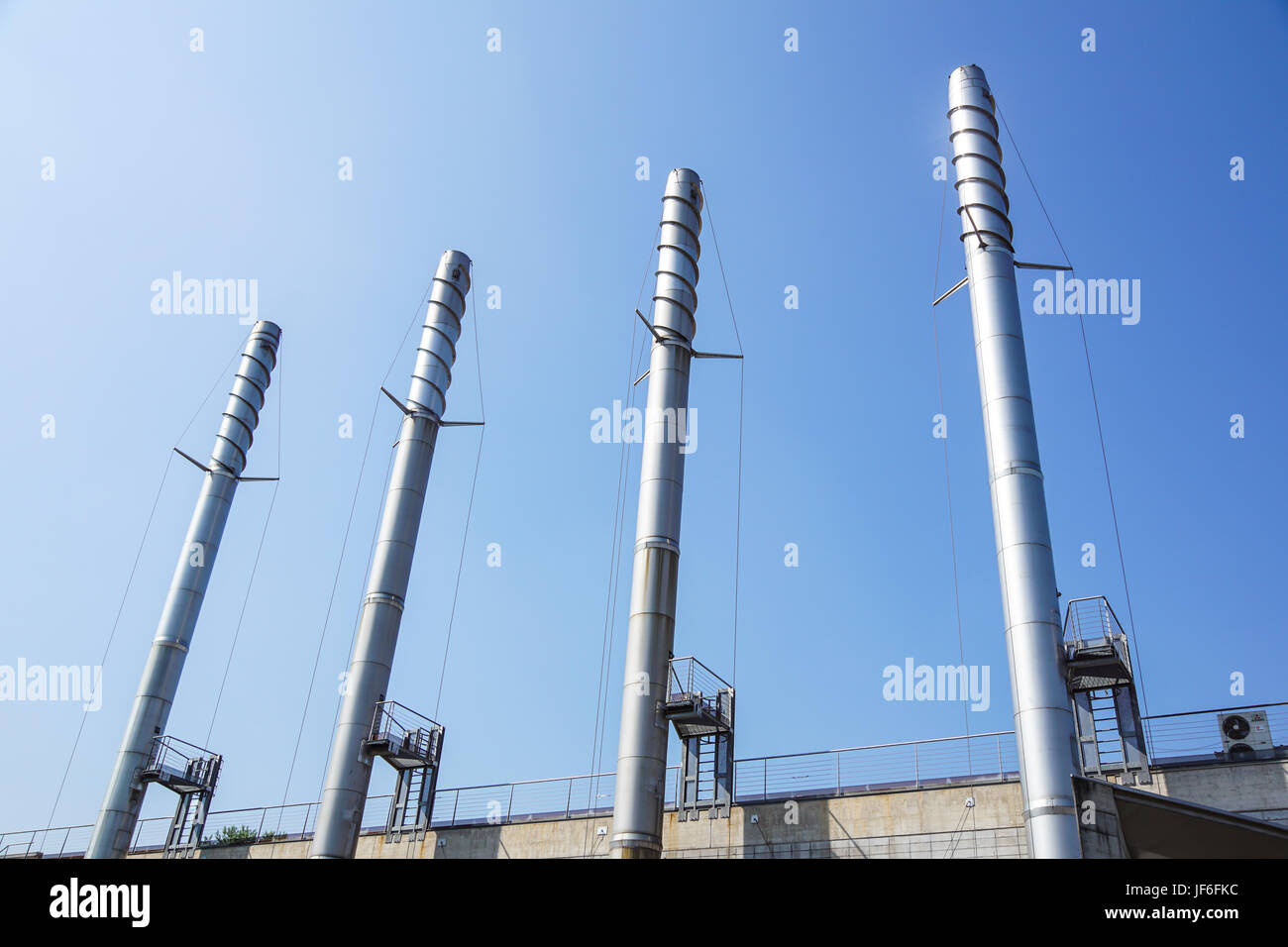 Metal chimneys with antivortic spiral and blue sky in the background ...