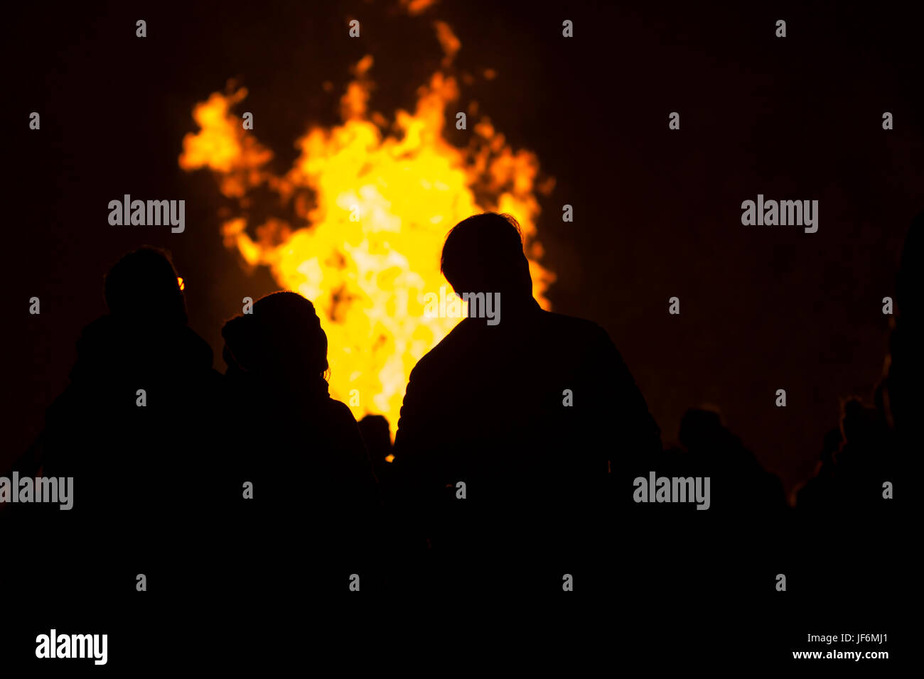 Silhouette of people watching a bonfire on bonfire night, rye, east ...