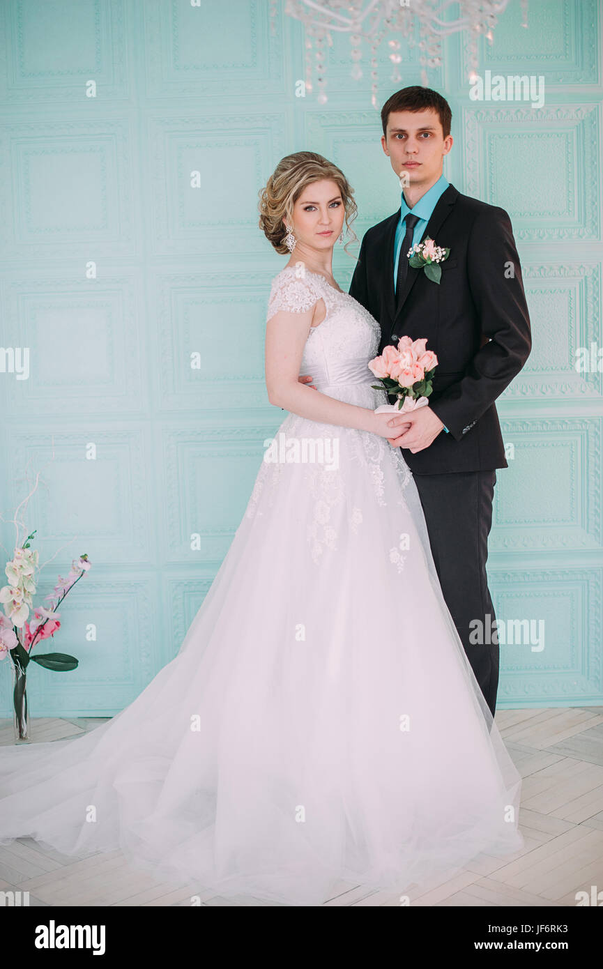 Happy couple. Wedding photo shoot in the white studio with wedding ...
