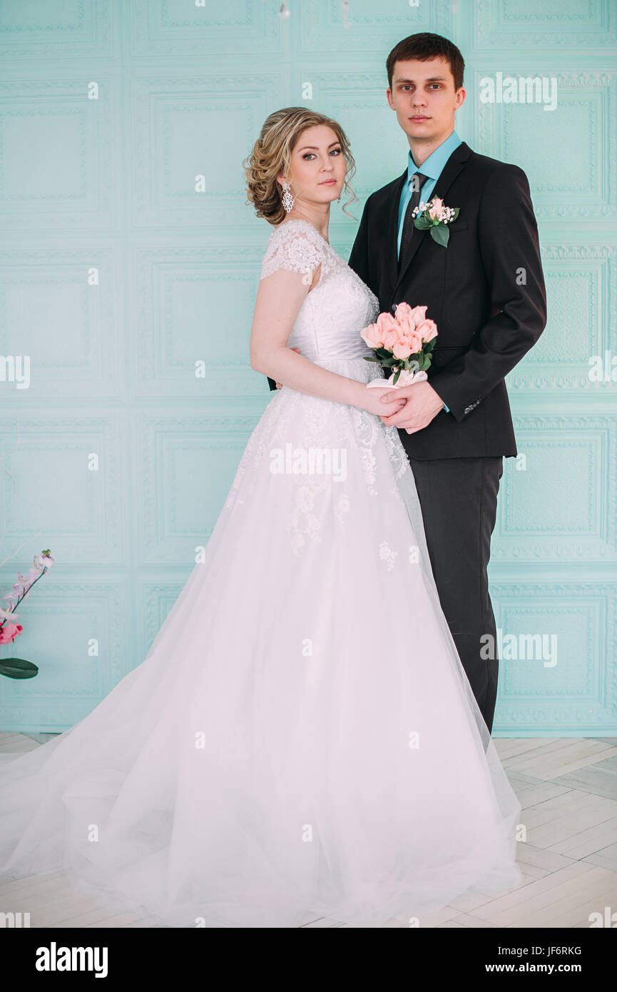 Happy couple. Wedding photo shoot in the white studio with wedding ...