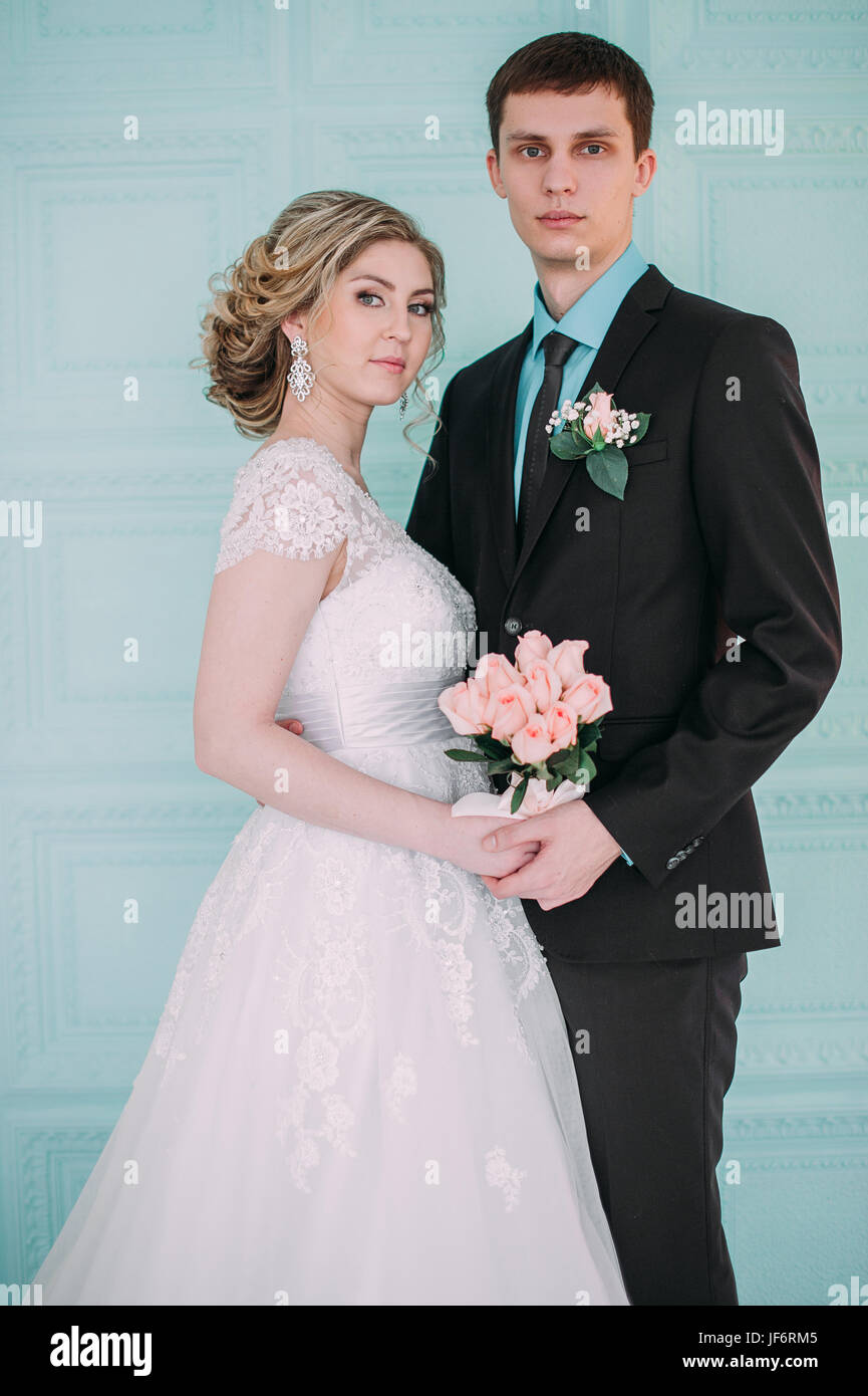Happy couple. Wedding photo shoot in the white studio with wedding ...