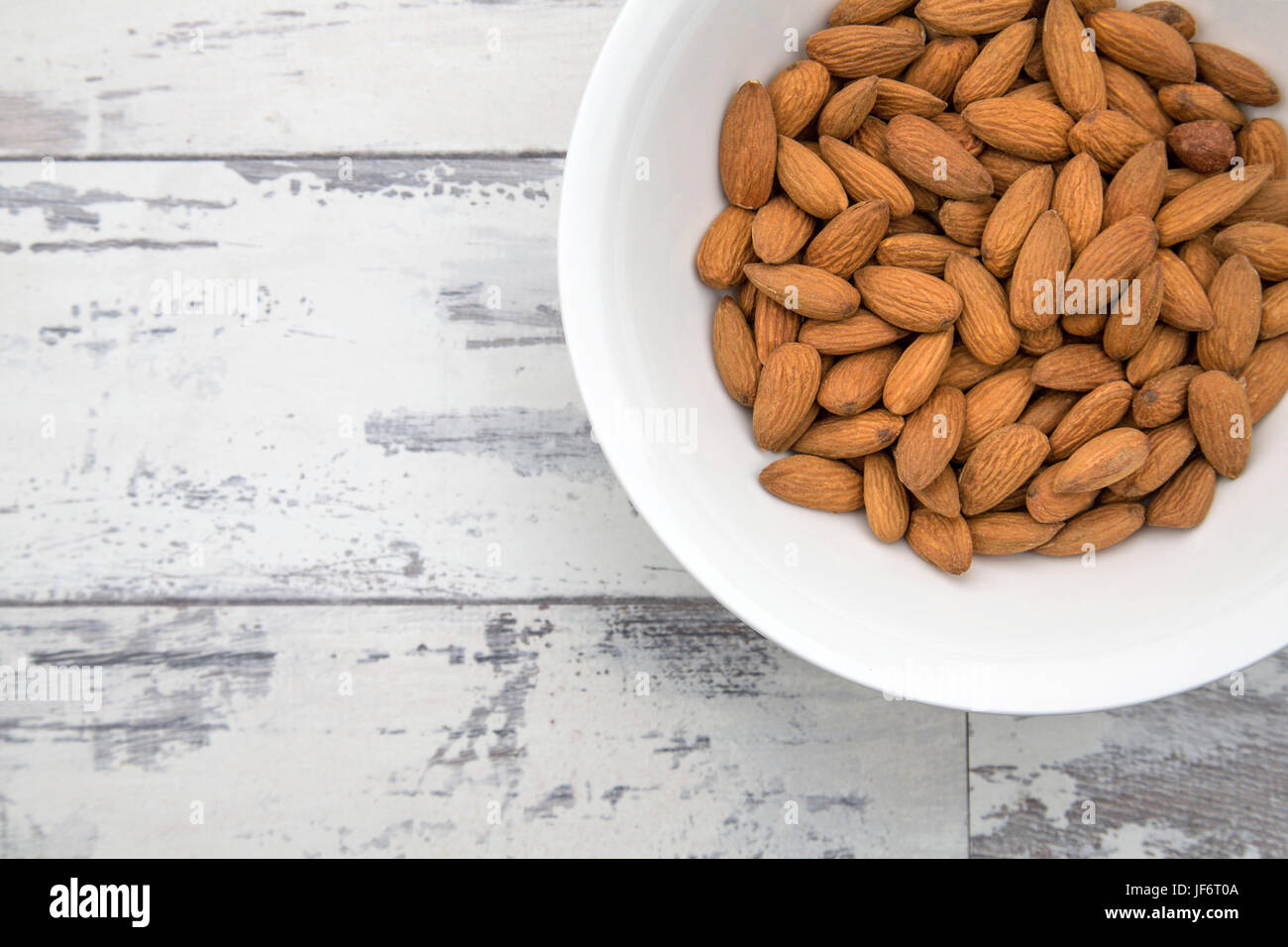 Almonds in a White Bowl on a Rustic Table Top in a Horizontal Format ...