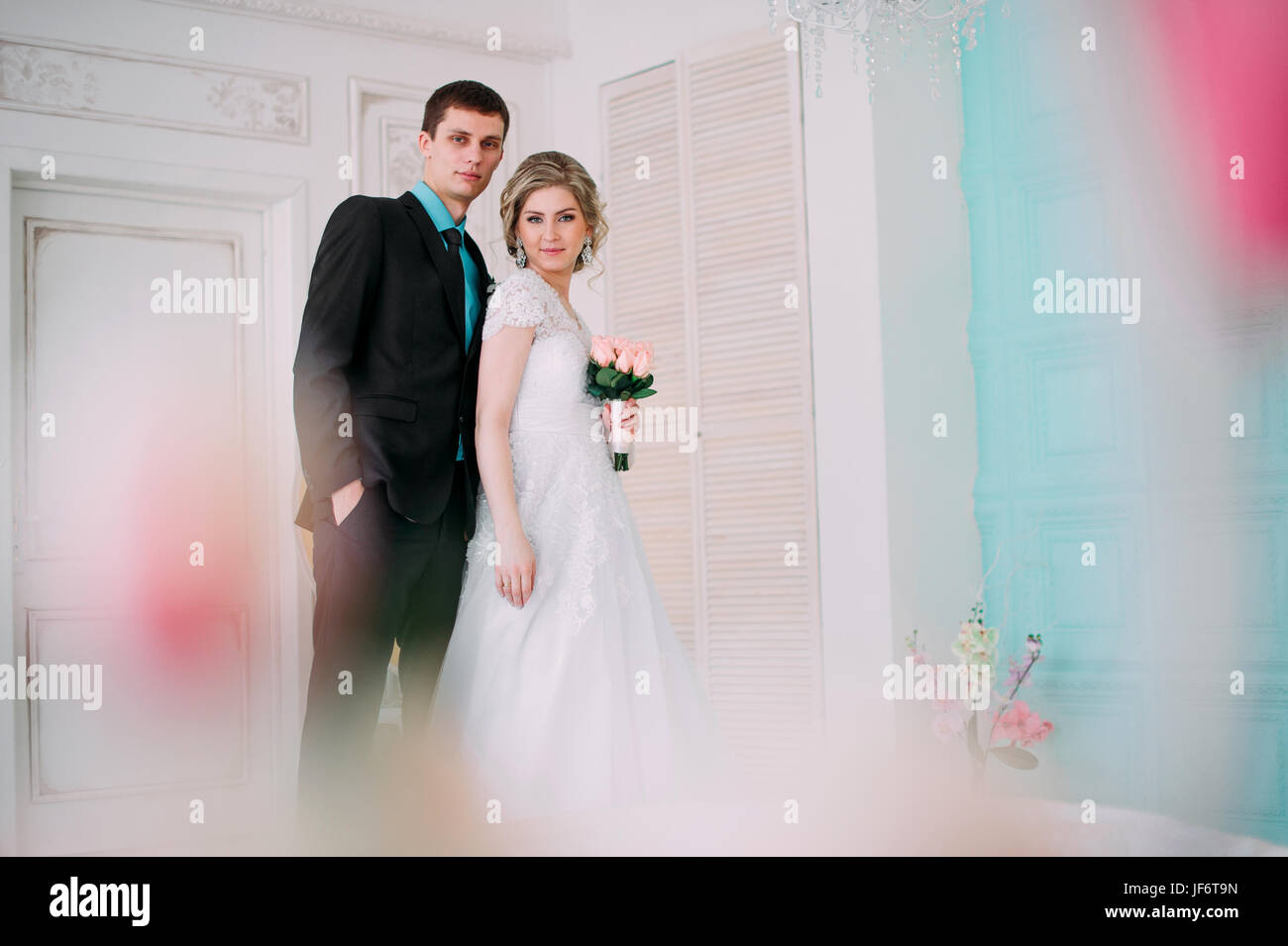 Happy couple. Wedding photo shoot in the white studio with wedding ...
