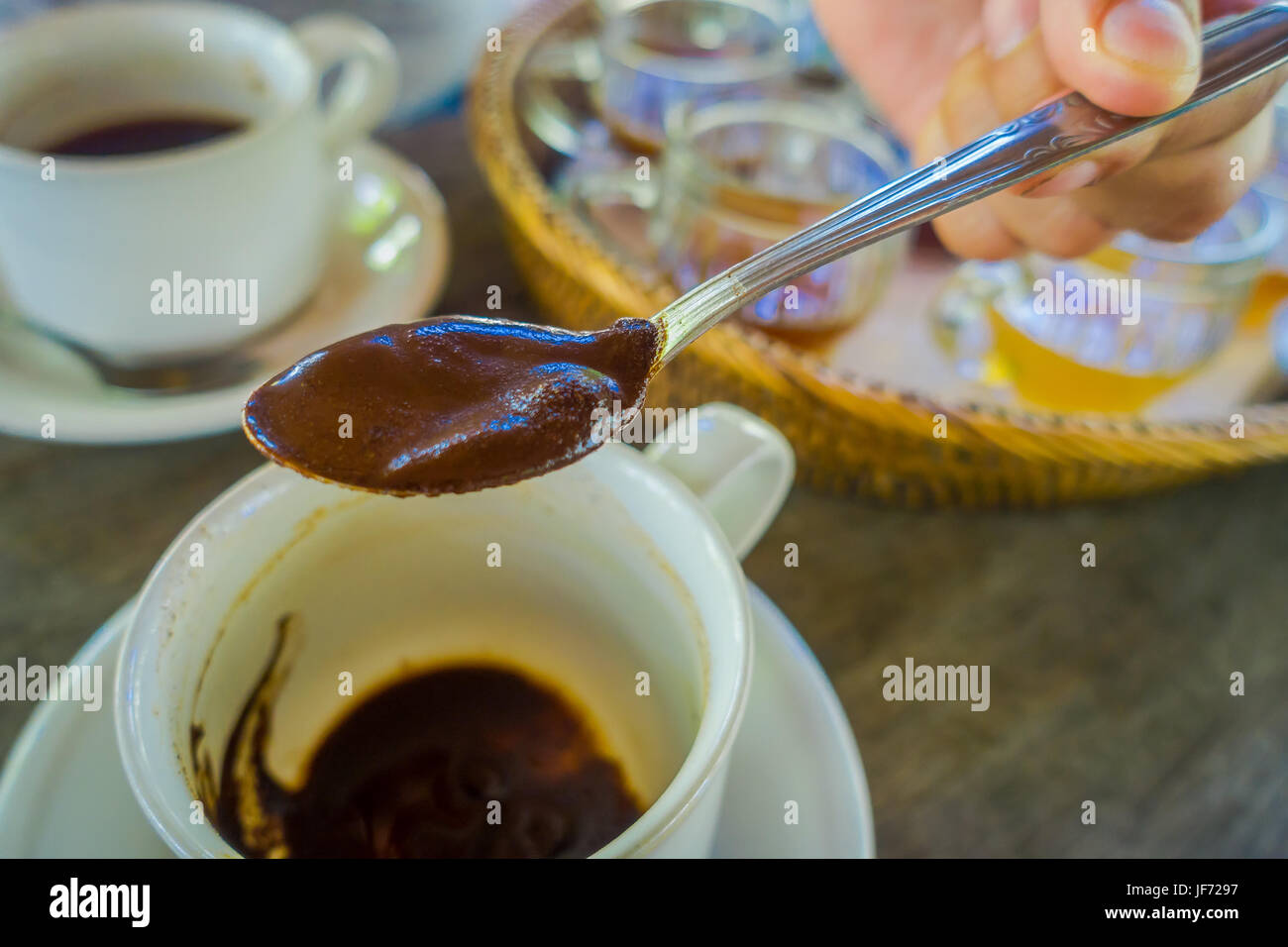 Hand adding with a spoon a Kopi Luwak Coffee from plantation in Bali ...