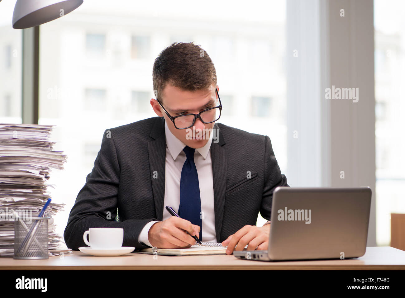 Young businessman drinking tea in the office Stock Photo - Alamy