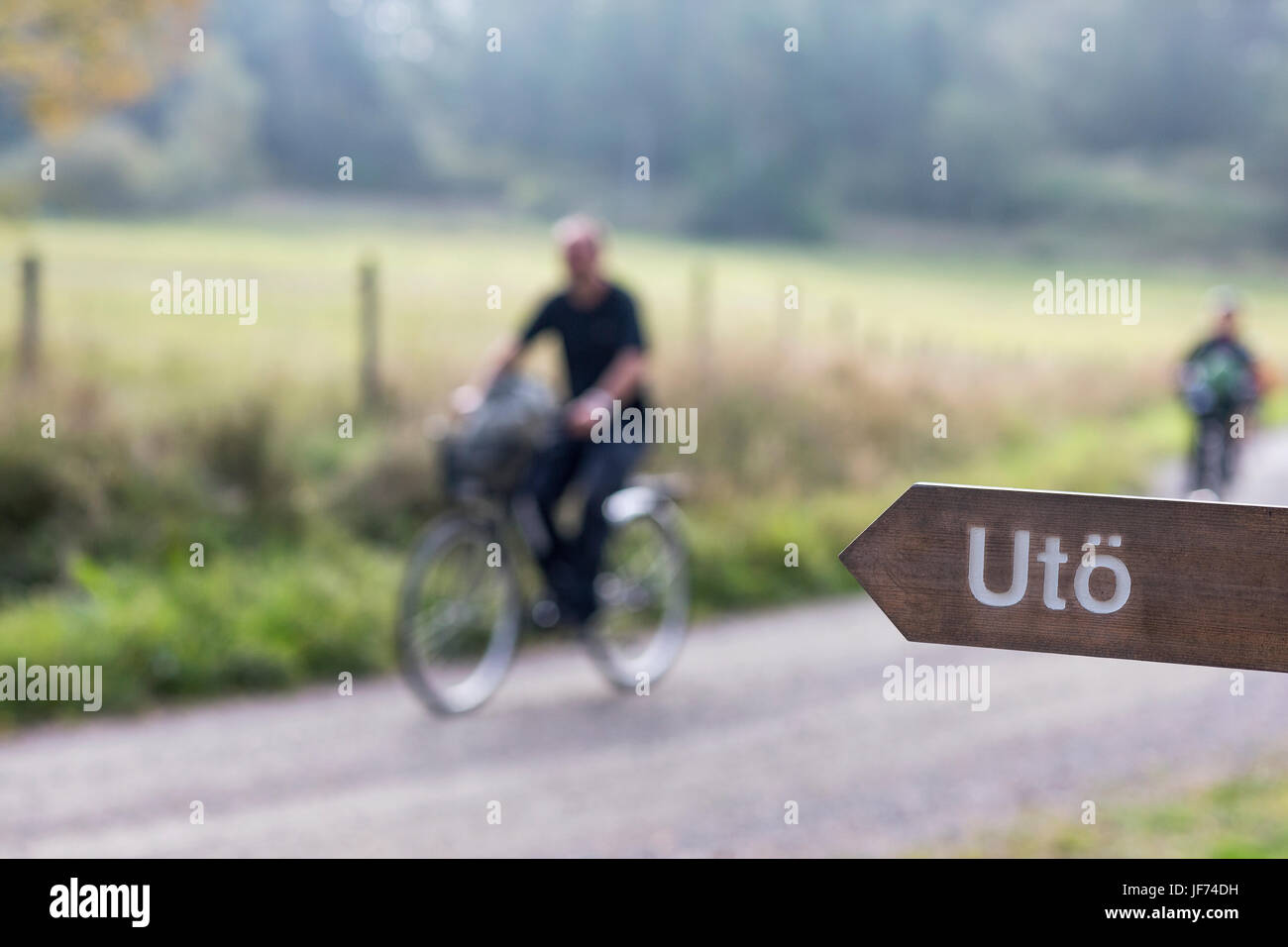 Directional sign with people cycling in background Stock Photo - Alamy