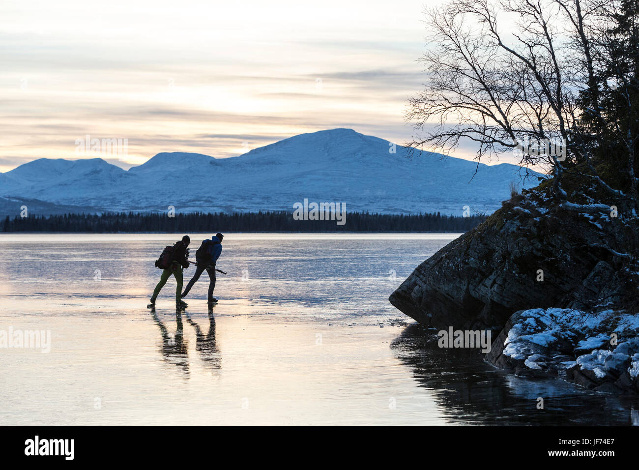 Two people moving on ice Stock Photo - Alamy