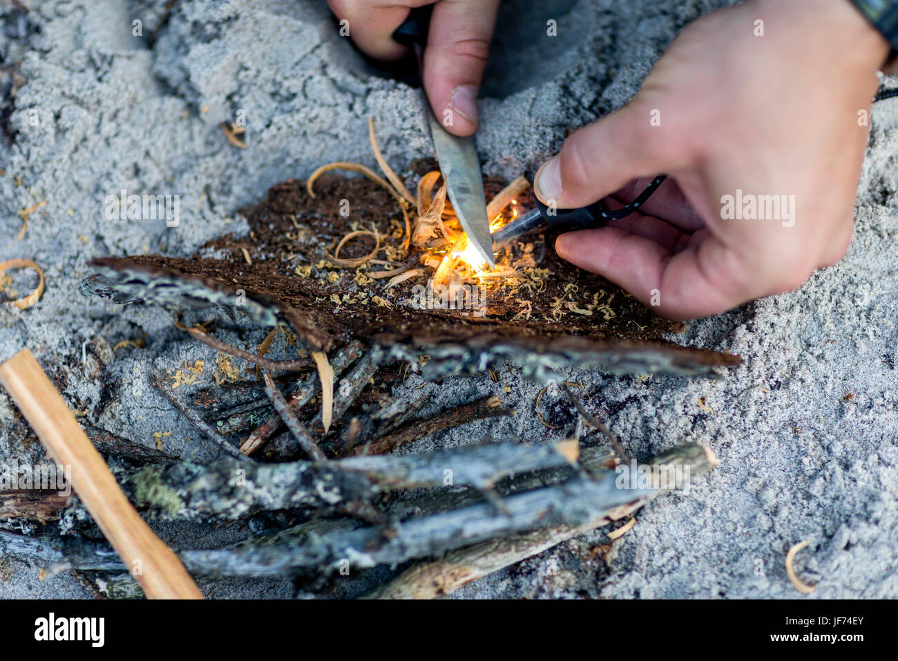 Man lighting fire on beach Stock Photo - Alamy