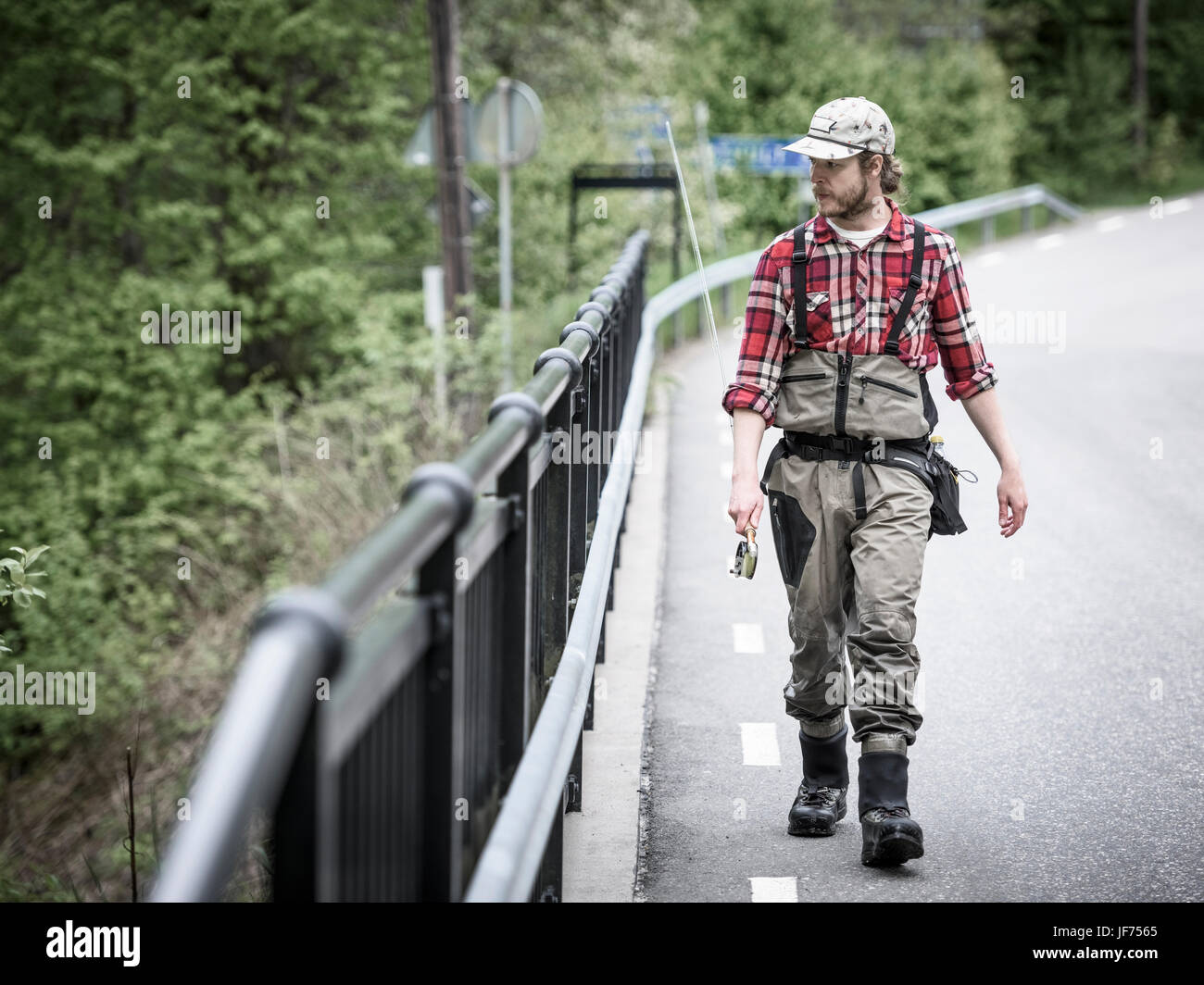 Fisherman walking on bridge Stock Photo - Alamy