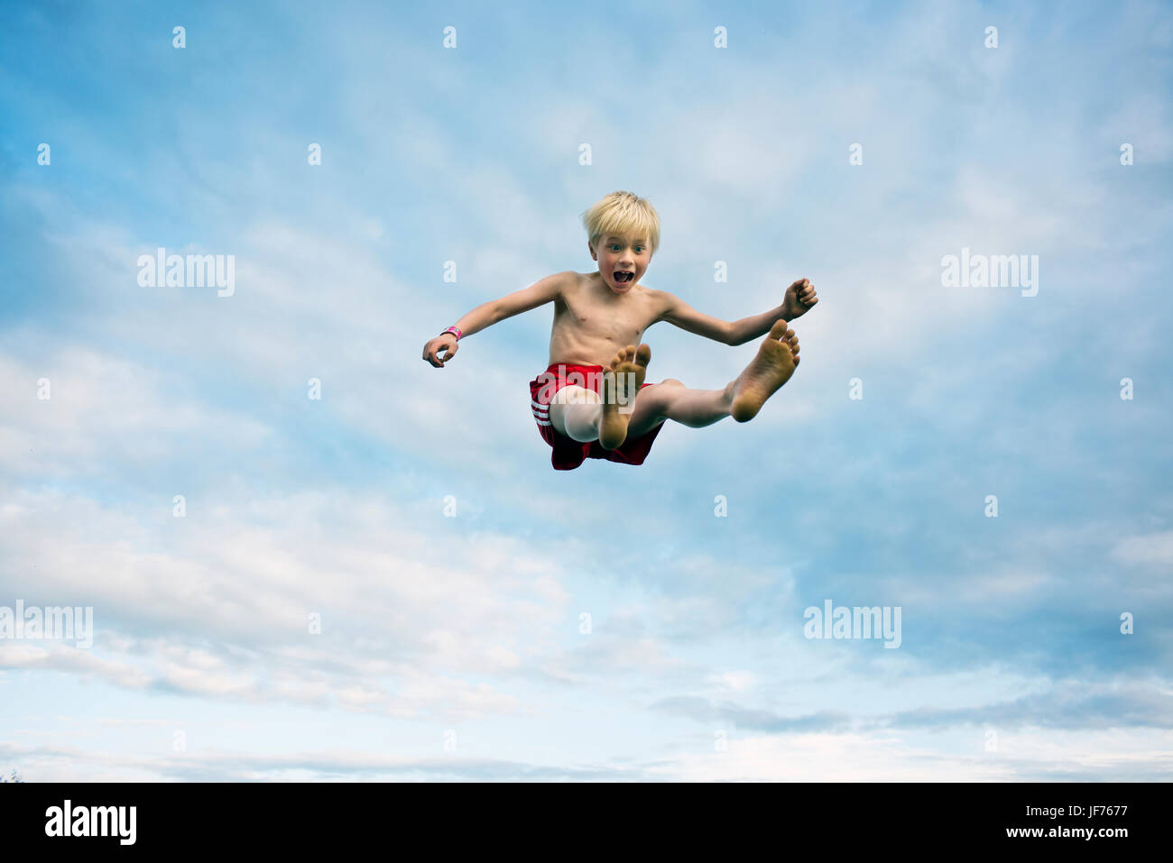 Boy jumping mid-air Stock Photo - Alamy
