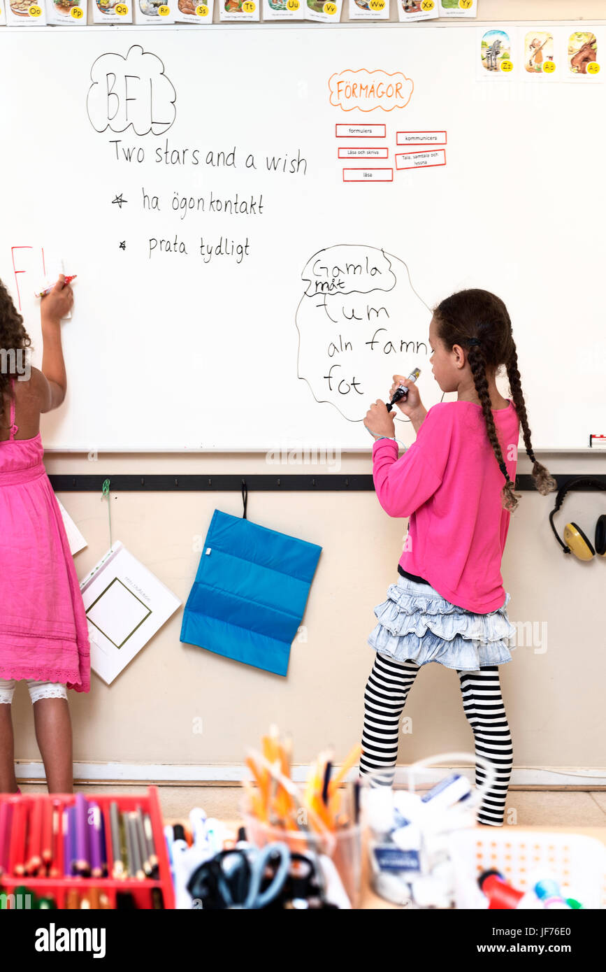 Girl writing on whiteboard Stock Photo - Alamy
