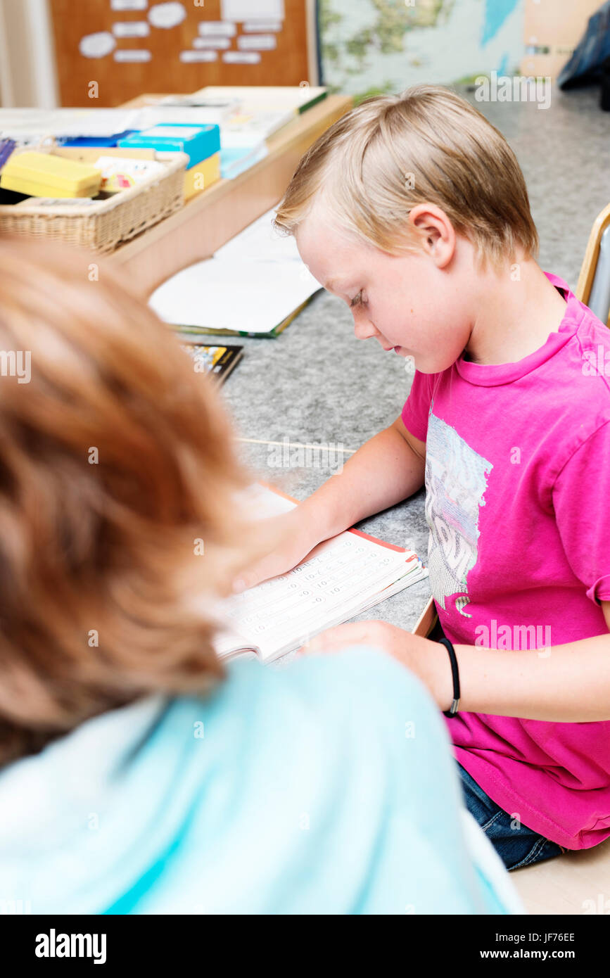 Teacher checking on students work Stock Photo - Alamy