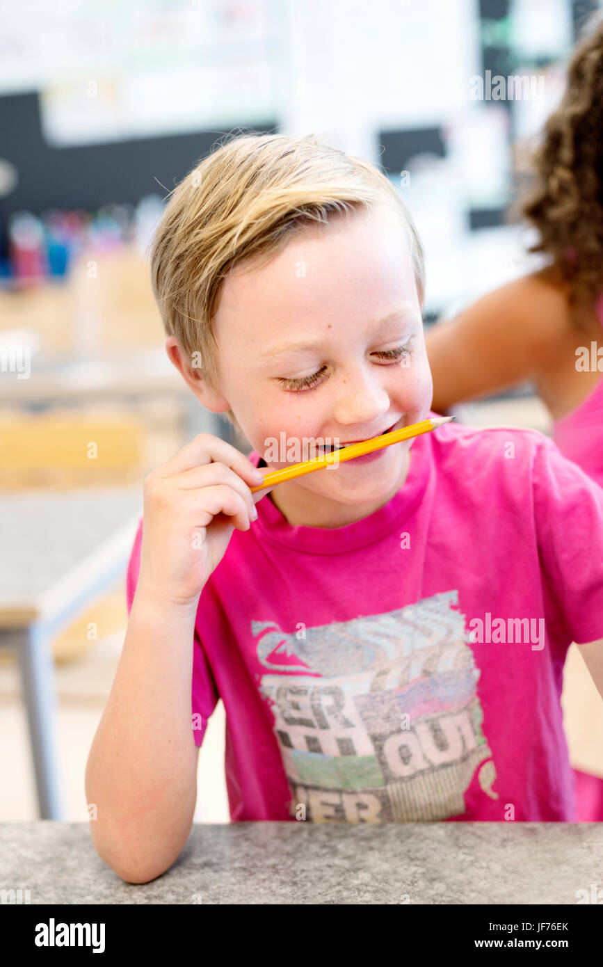 Boy holding pencil in mouth Stock Photo - Alamy