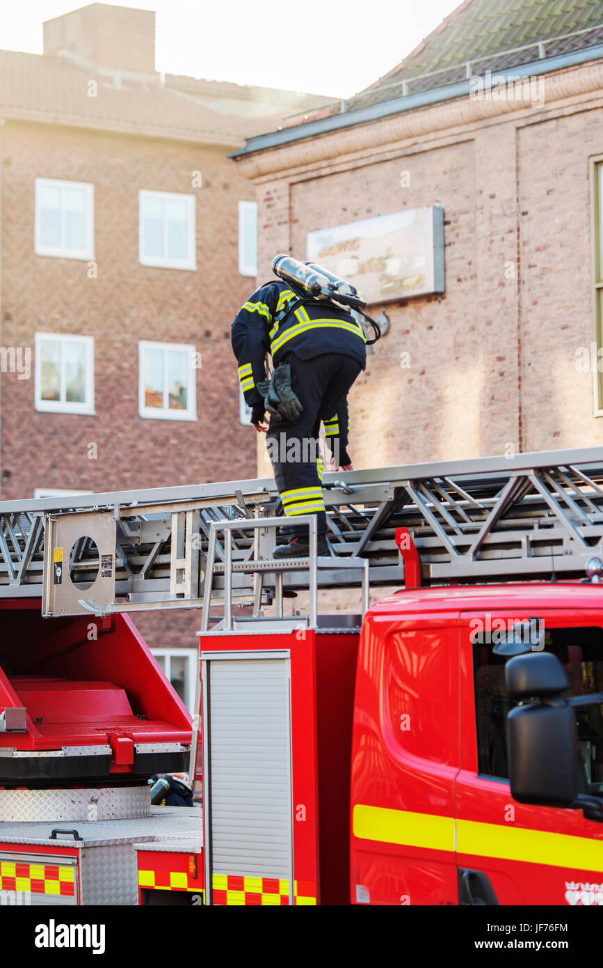 Fireman standing on fire engine Stock Photo - Alamy