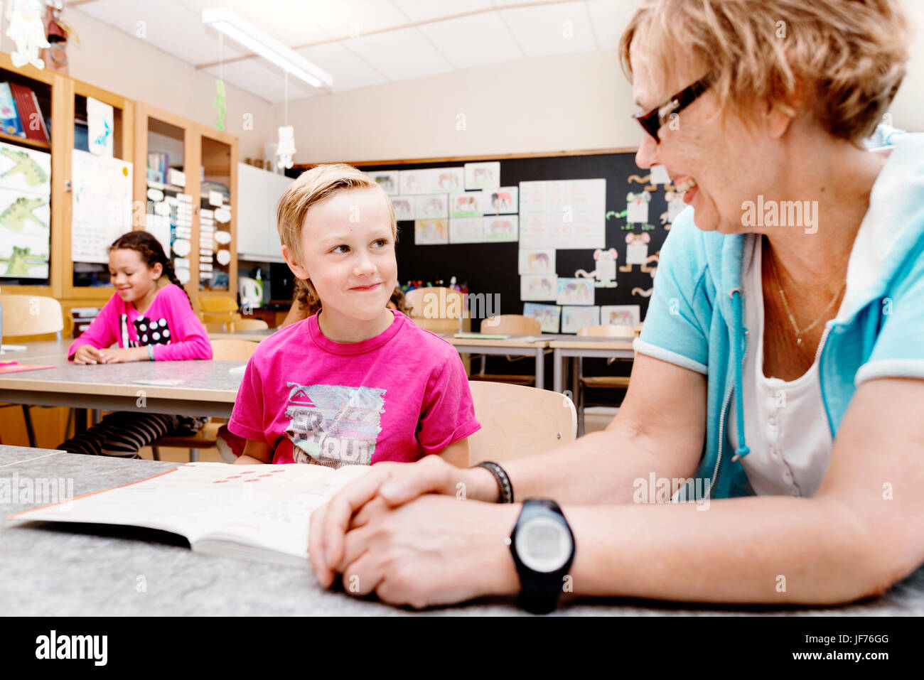 Teacher assisting students in classroom Stock Photo - Alamy