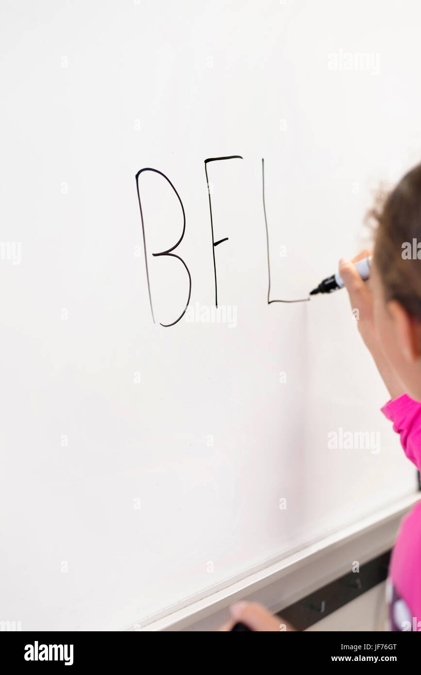 Girl writing on whiteboard Stock Photo - Alamy