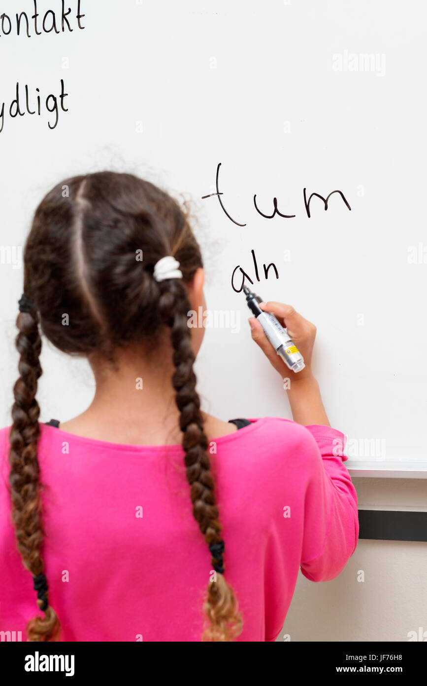 Girl writing on whiteboard Stock Photo - Alamy