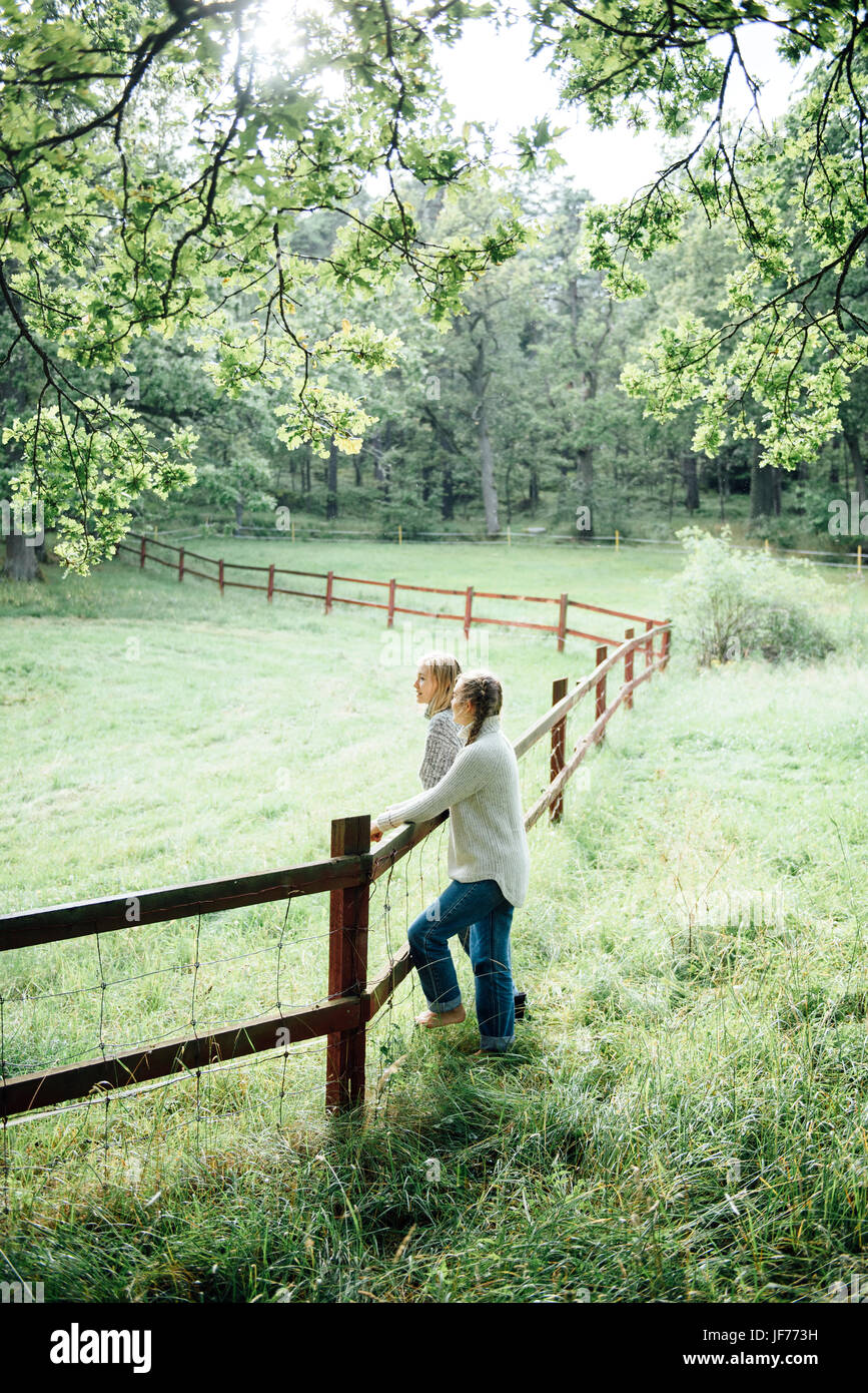 Two women at a fence Stock Photo - Alamy