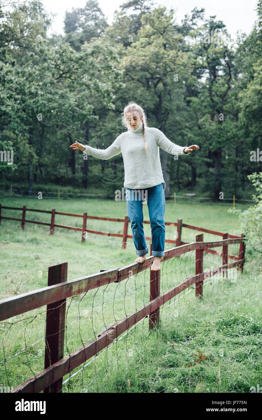 Woman balance on a fence Stock Photo - Alamy