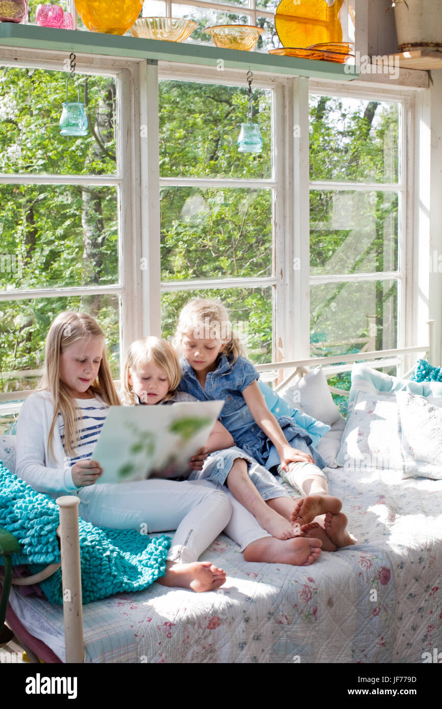 Three girls reading book Stock Photo - Alamy