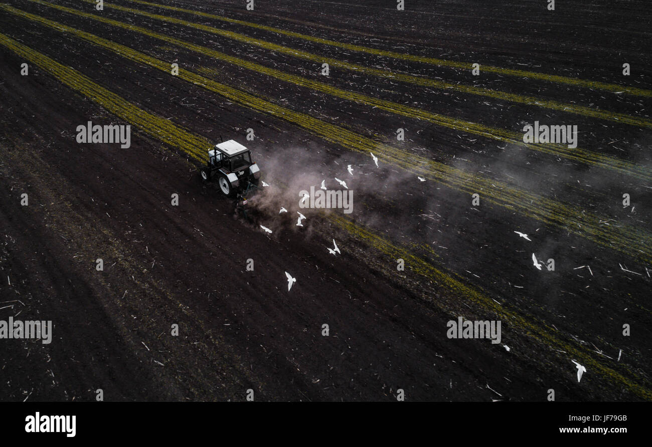 Tractor cultivating field at spring, aerial view Stock Photo - Alamy