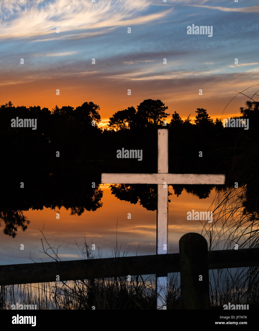White cross by a lake at sunset Stock Photo - Alamy