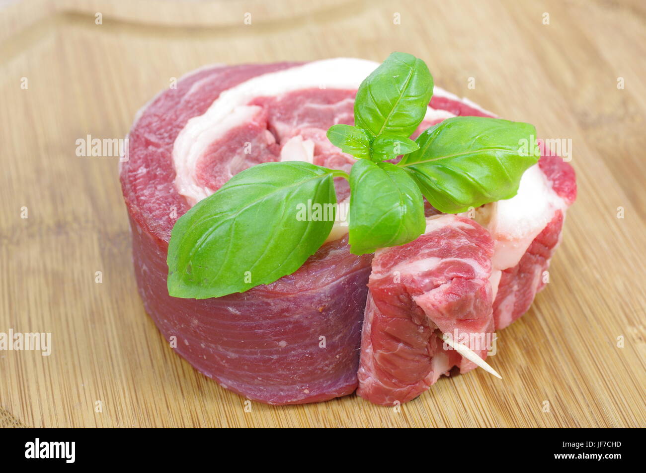 coiled raw beef with basil on cutting board Stock Photo - Alamy