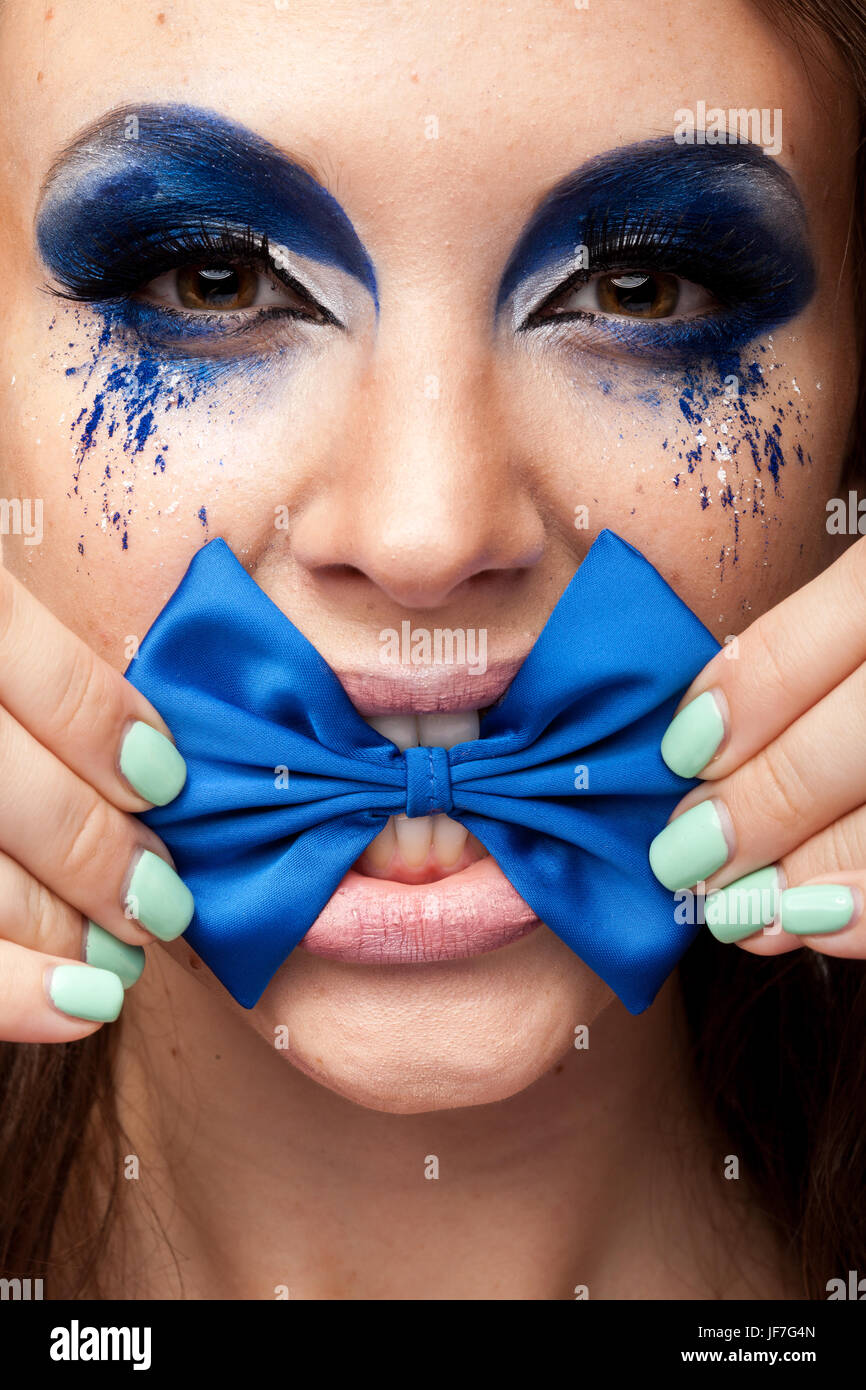 Gorgeous woman with bow in mouth Stock Photo - Alamy