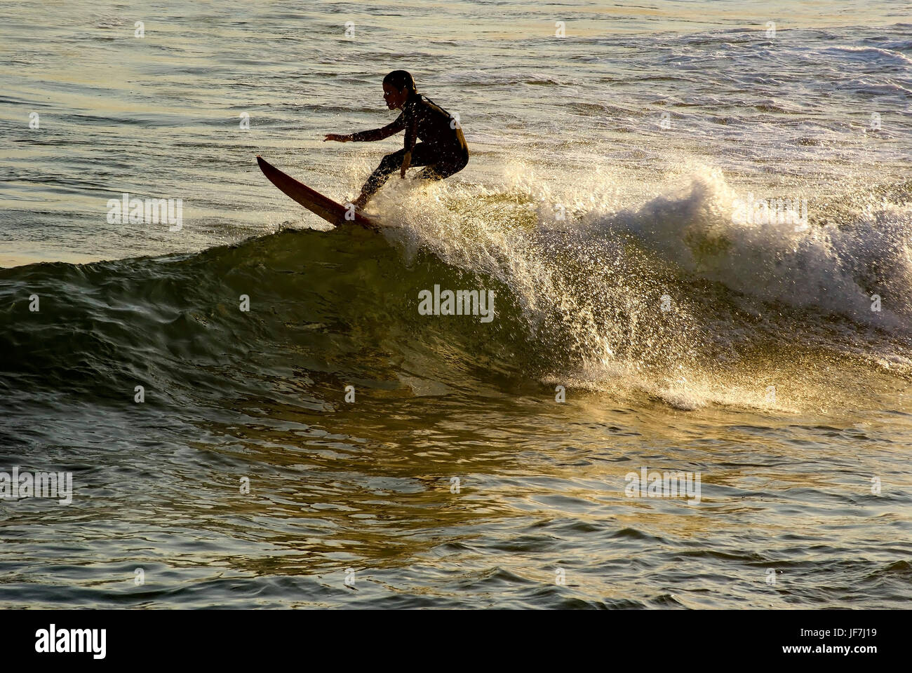 Boy surfing small wave at Arpoador beach in Ipanema during sunset Stock ...