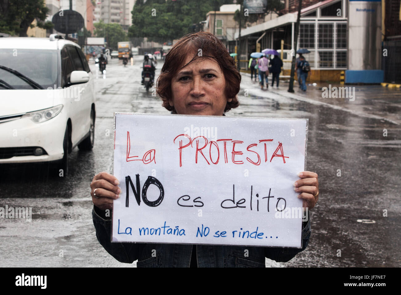 A female demonstrator holding a cardboard sign during a protest in ...