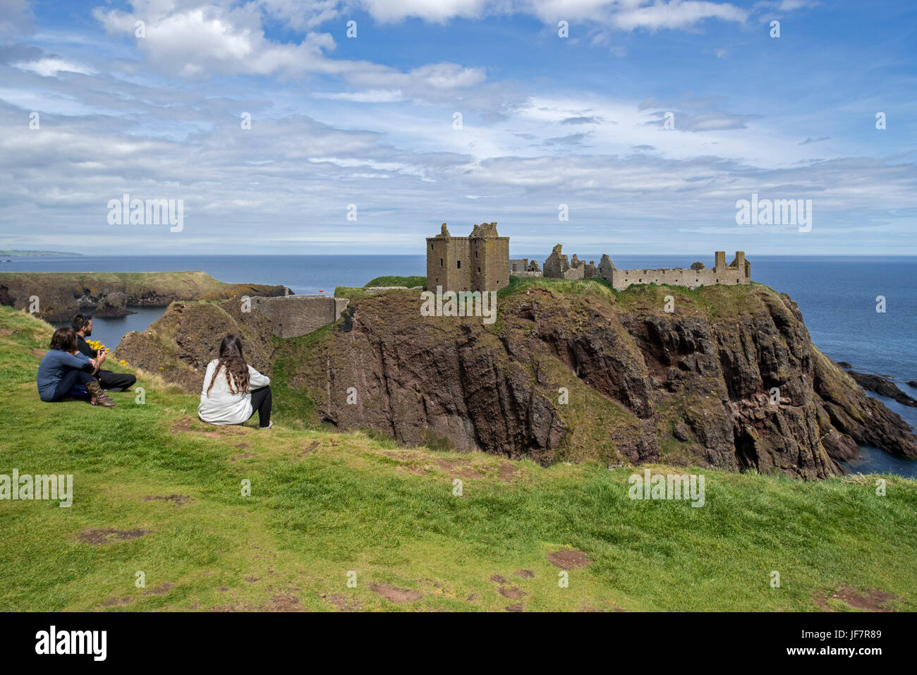 Tourists looking at Dunnottar Castle, ruined medieval fortress near ...