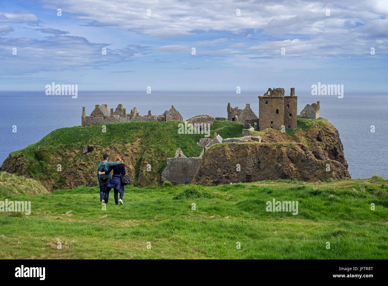 Tourists looking at Dunnottar Castle, ruined medieval fortress near ...