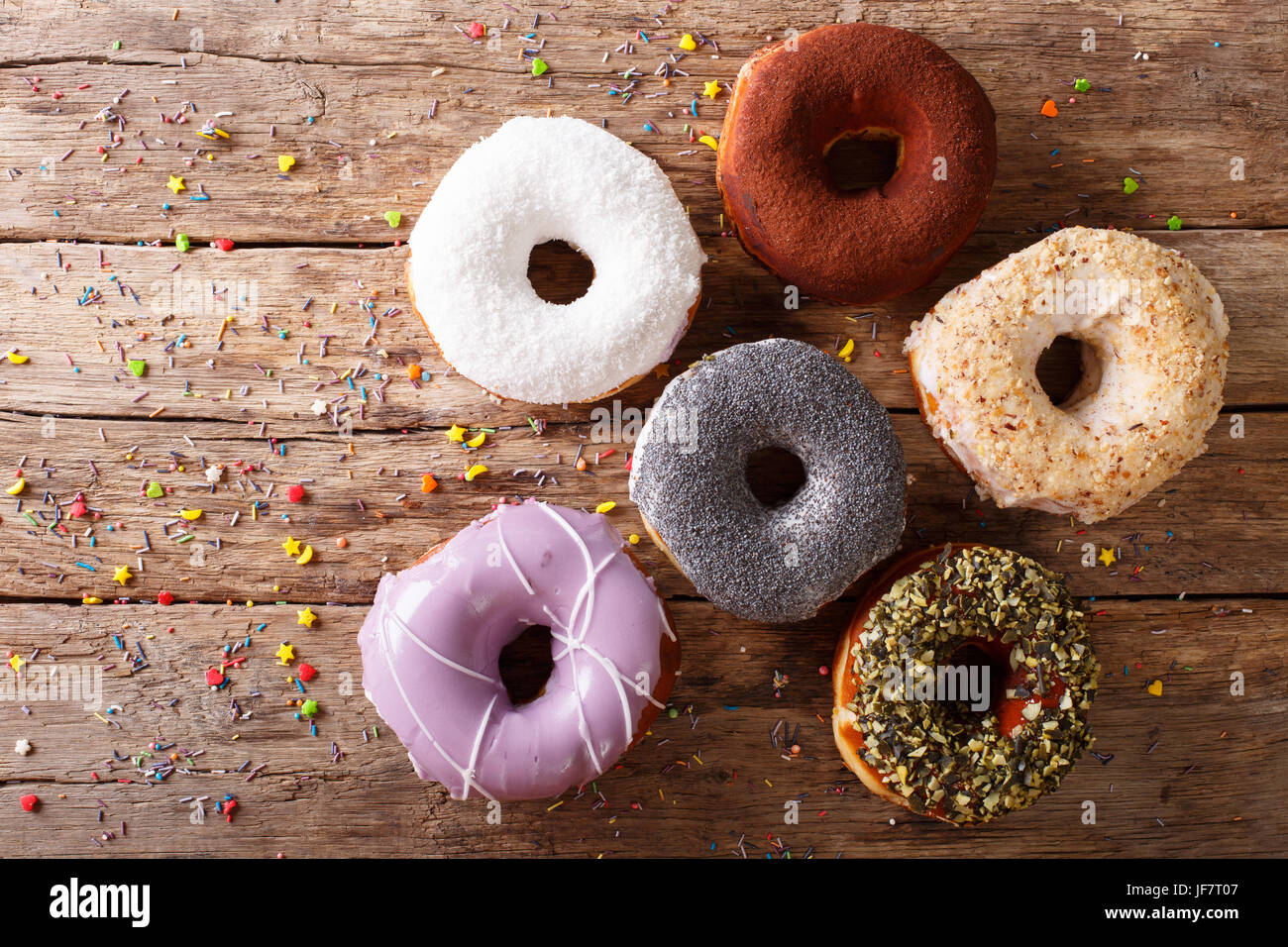 Multicolored donuts with fillings close-up on the table. horizontal ...