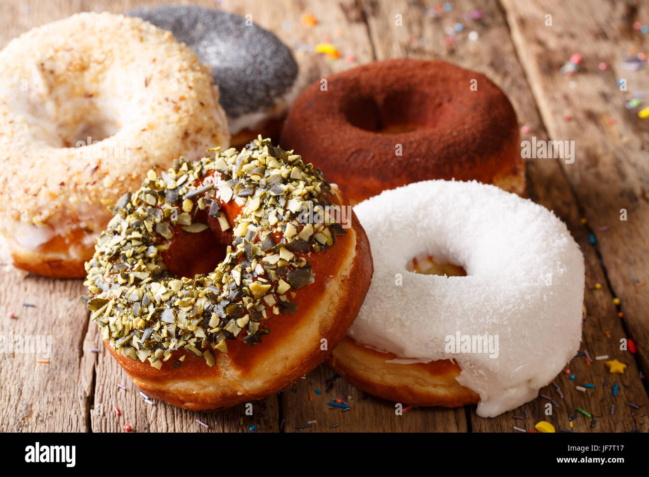 Glazed donuts with sunflower seeds and poppies close-up on the table ...