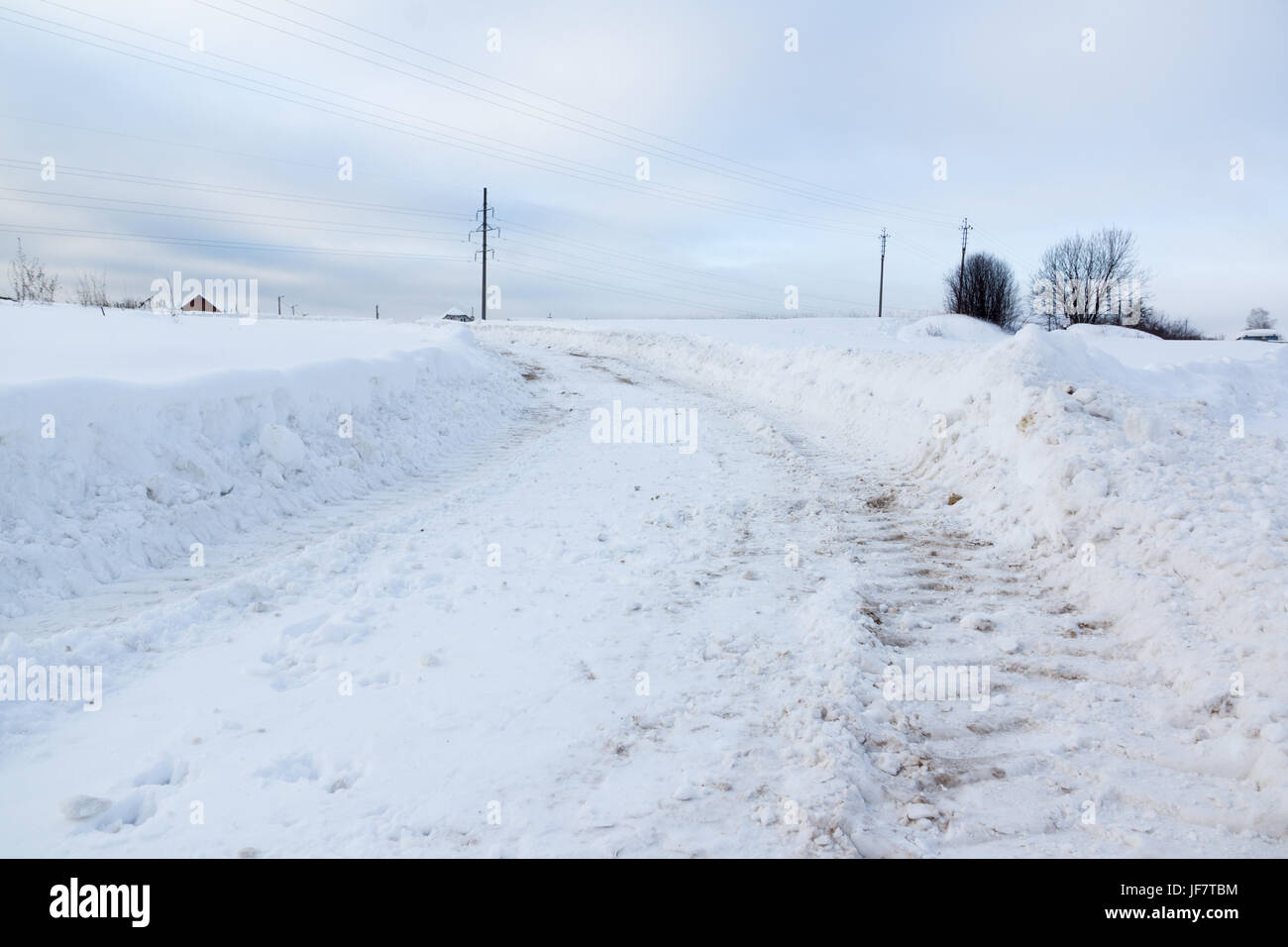 snowy winter road runs through the village with build Stock Photo - Alamy
