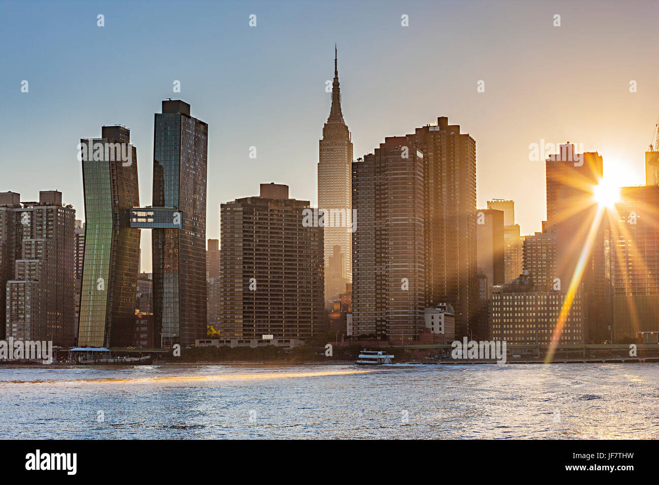 The Sun is shining through a Manhattan buildings in the New York City ...