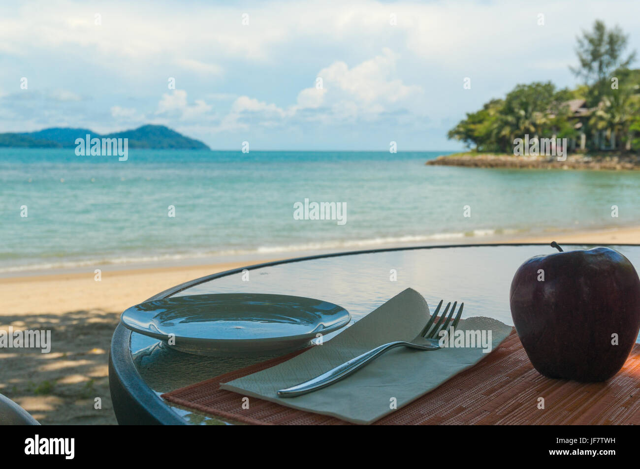 Table on the beach with cutlery and an apple Stock Photo - Alamy