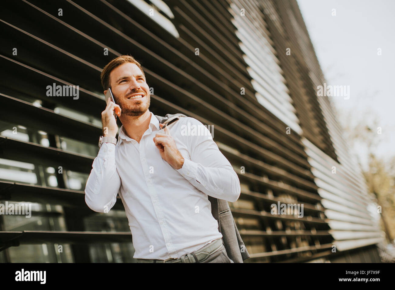View at Young successful men entrepreneur using mobile phone outdoor ...