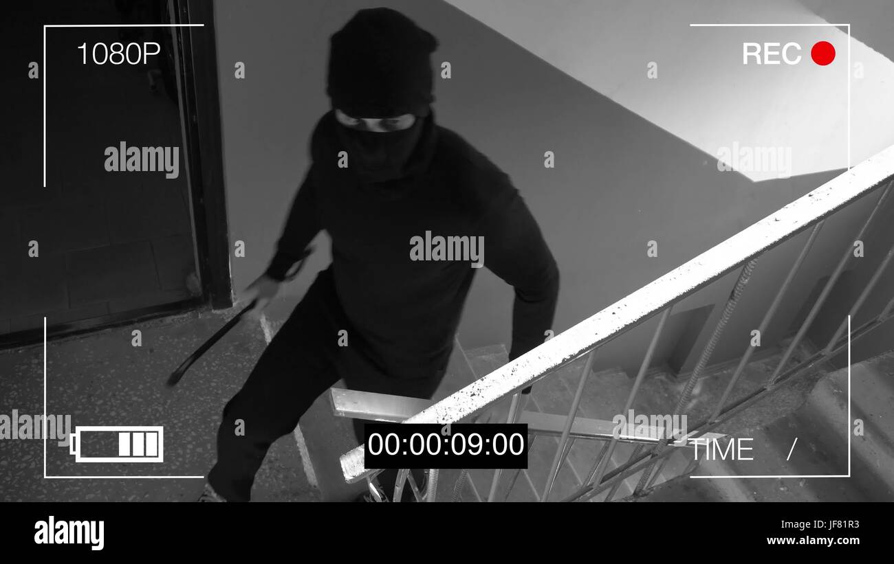surveillance camera caught the robber in a mask with a crowbar Stock ...