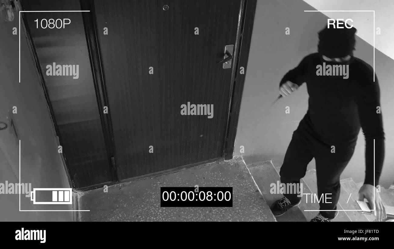 surveillance camera caught the robber in a mask with a knife Stock ...