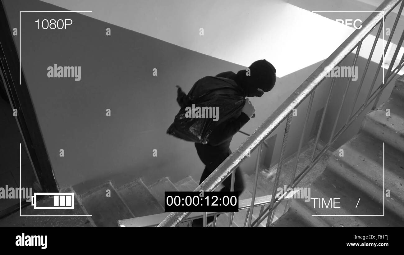 surveillance camera caught the robber in a mask running off with a bag ...