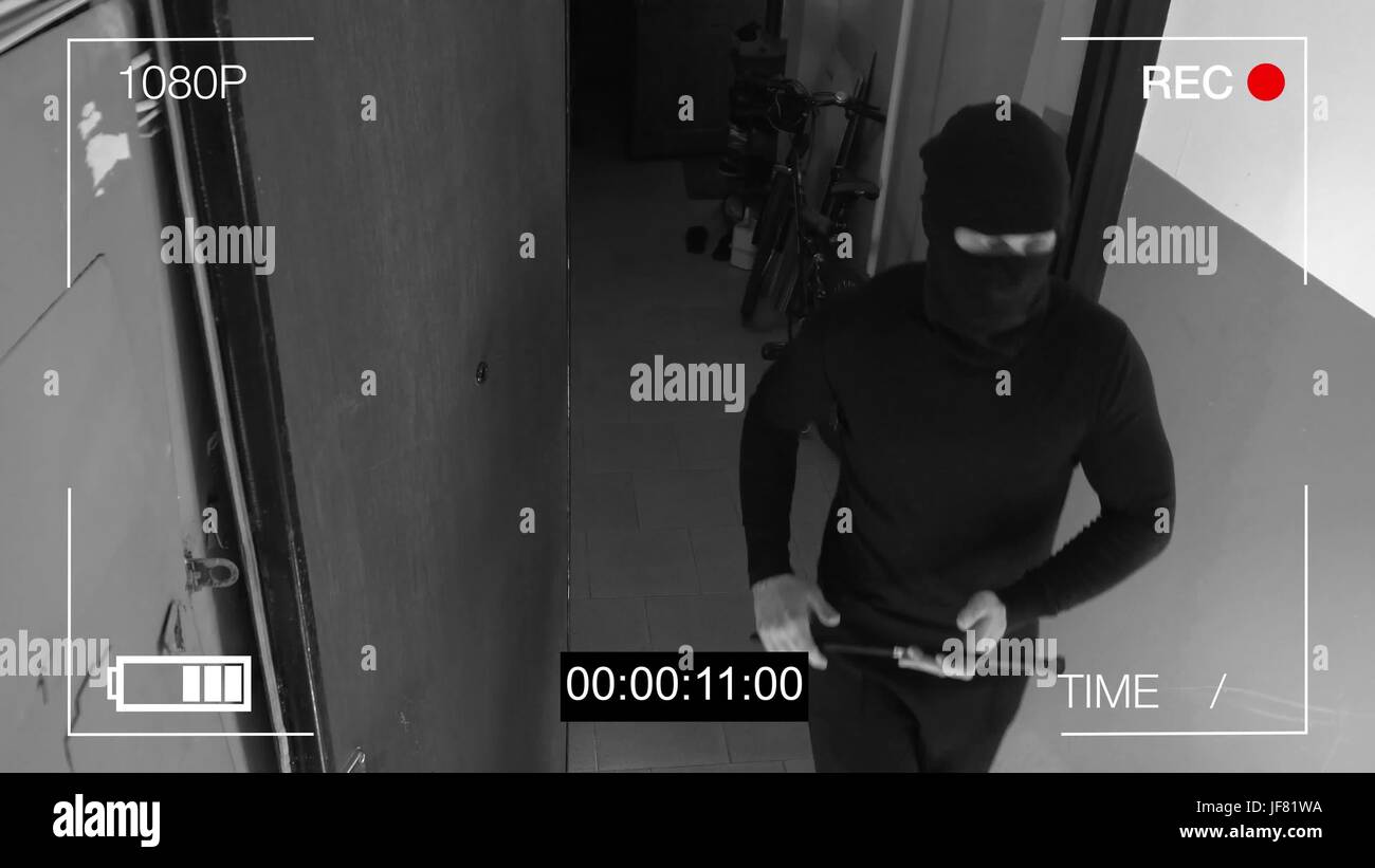 surveillance camera caught the robber in a mask with a crowbar Stock ...